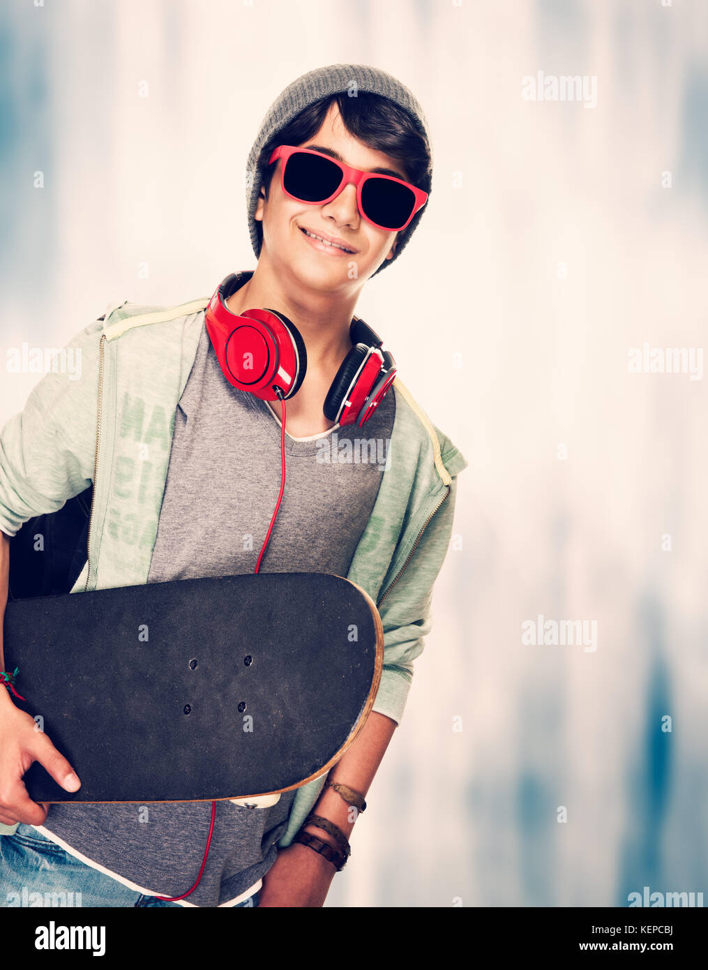 Teen skateboarder wearing stylish hat and sunglasses listening music on ...