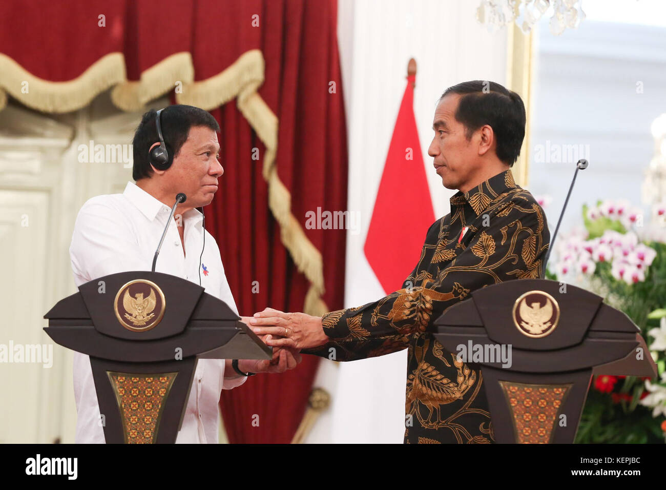 President Rodrigo Duterte clasps hands with Indonesian President Joko ...