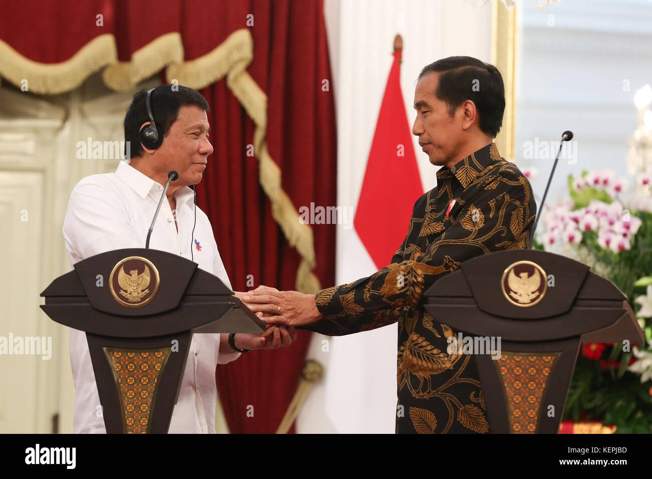 President Rodrigo Duterte clasps hands with Indonesian President Joko ...