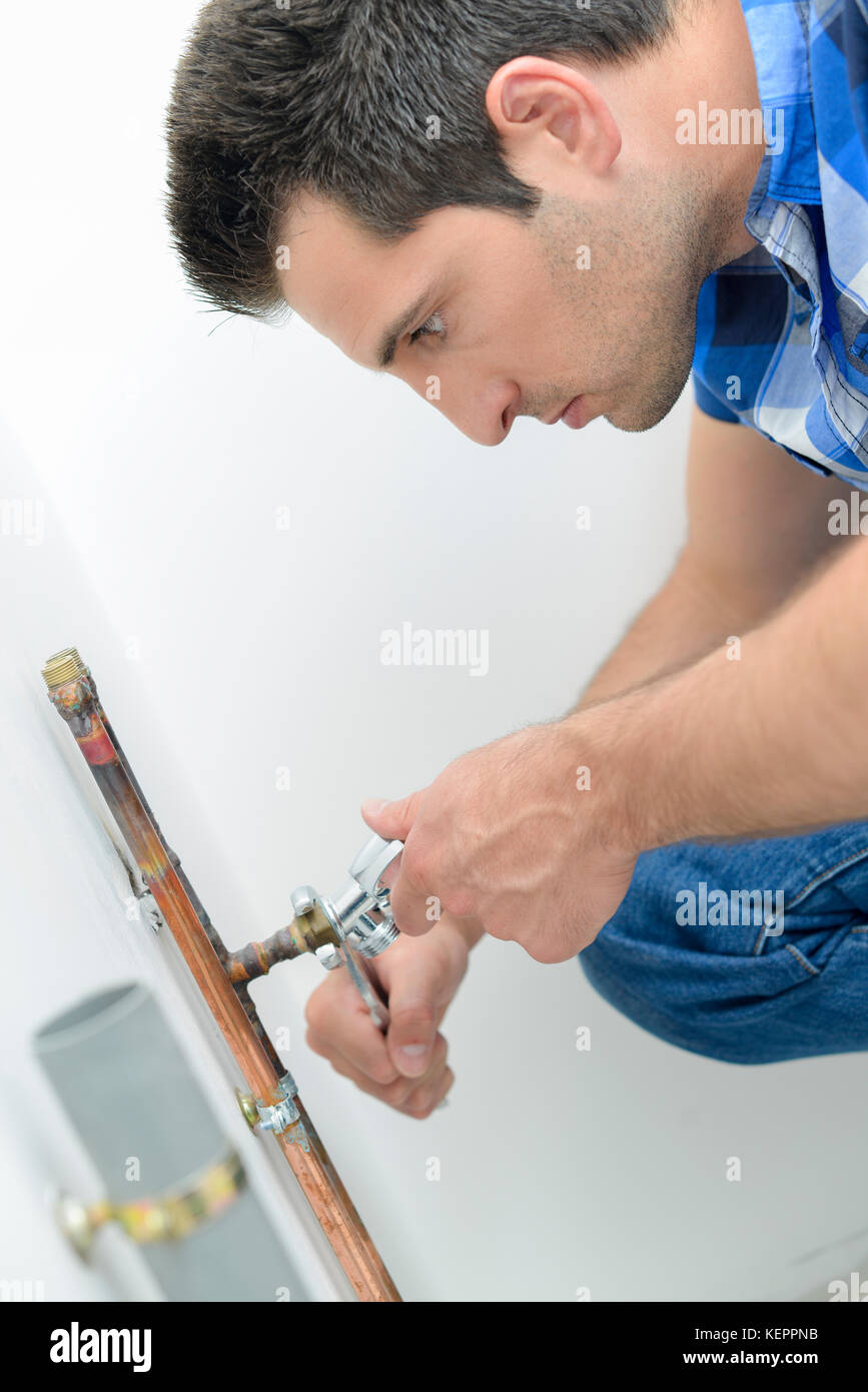Man tightening nut with wrench Stock Photo - Alamy