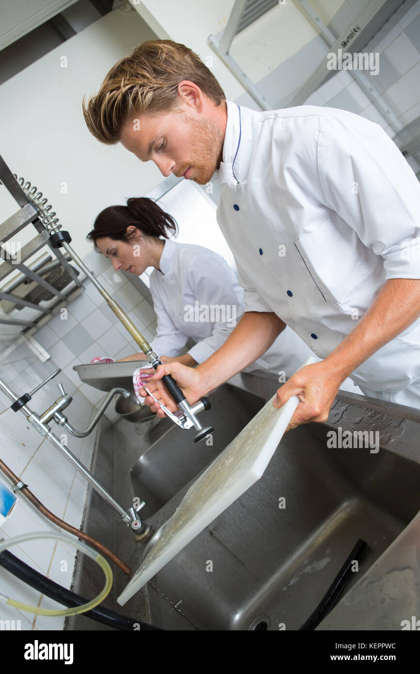 washing and cleaning meat board at the kitchen sink Stock Photo - Alamy