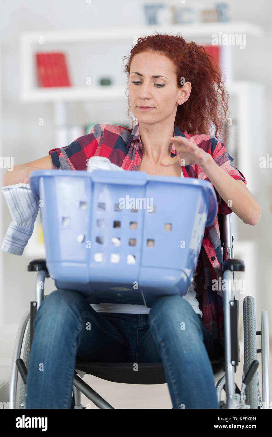 handicapped woman sitting in wheelchair doing her laundry at home Stock ...