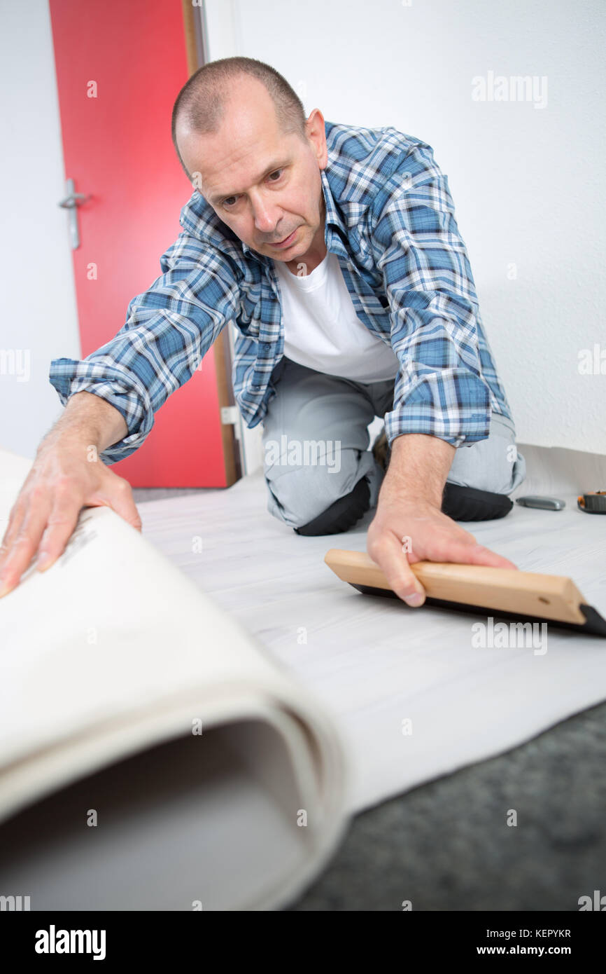 craftsman fitting a carpet Stock Photo - Alamy