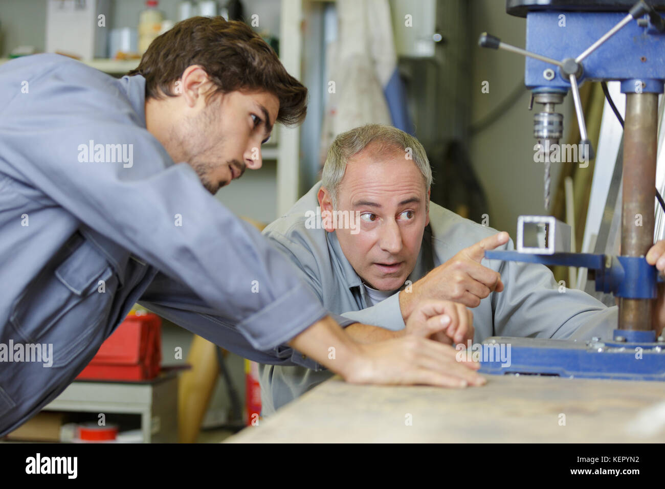 engineer teaching apprentice to use milling machine Stock Photo - Alamy