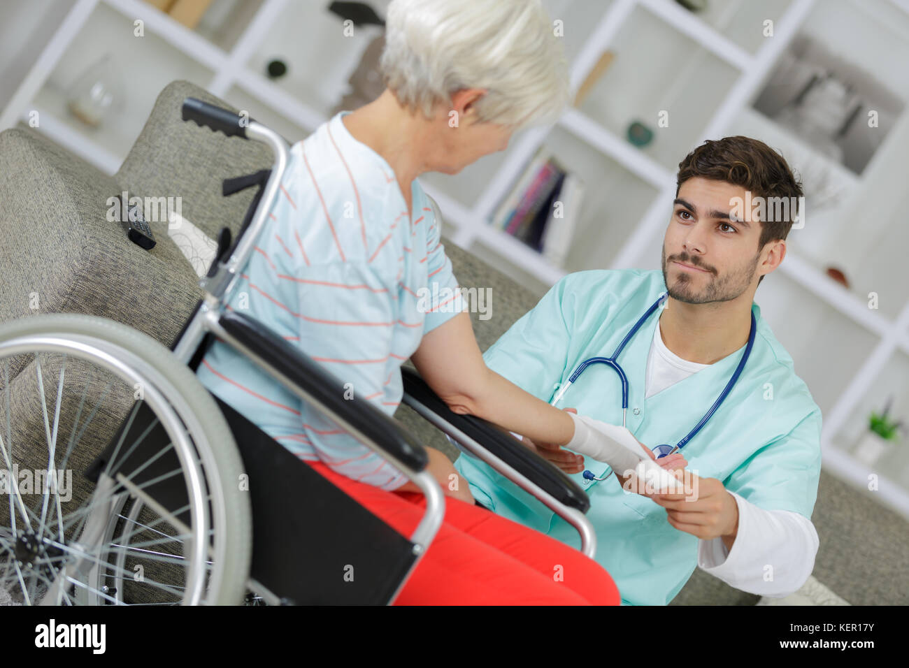 Young carer smiling pitifully at senior woman Stock Photo - Alamy