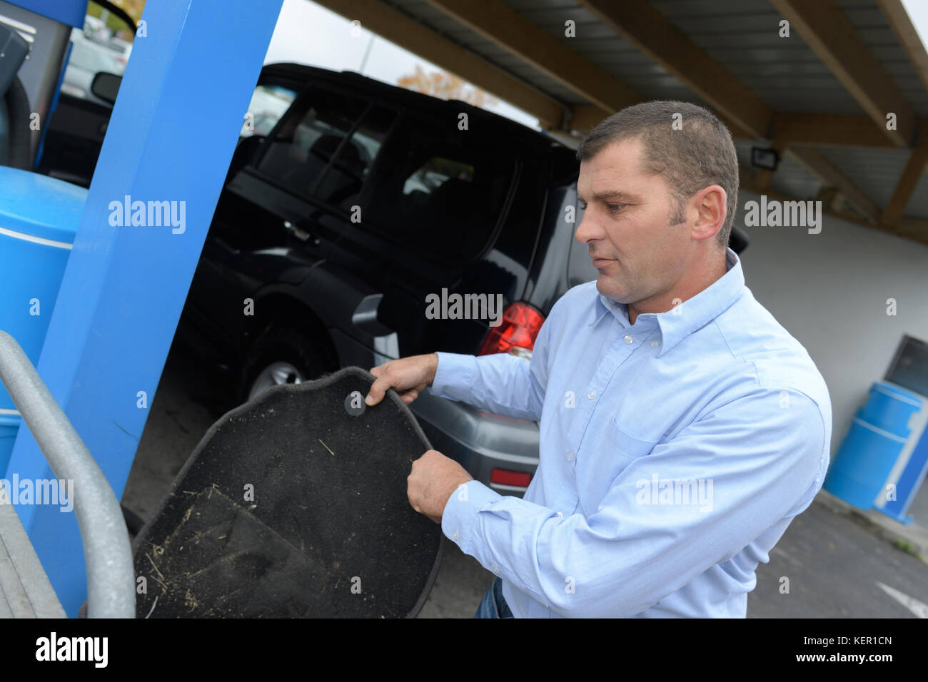 man cleaning a car mat Stock Photo - Alamy