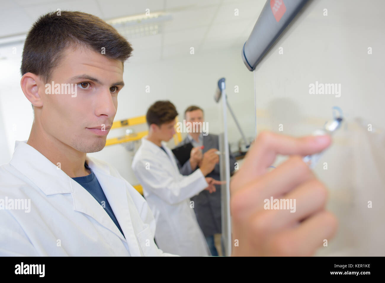 Young man writing on whiteboard Stock Photo - Alamy