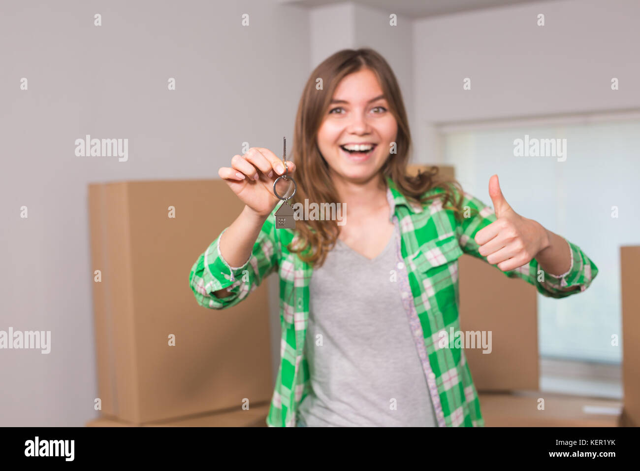 Happy apartment owner or renter showing keys and making thumbs up ...