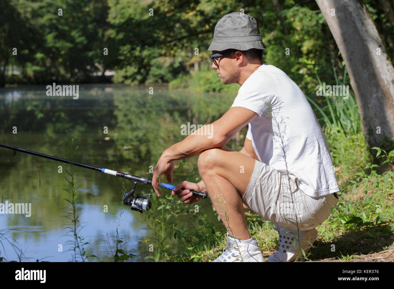 fisher man fishing at lakeside Stock Photo - Alamy