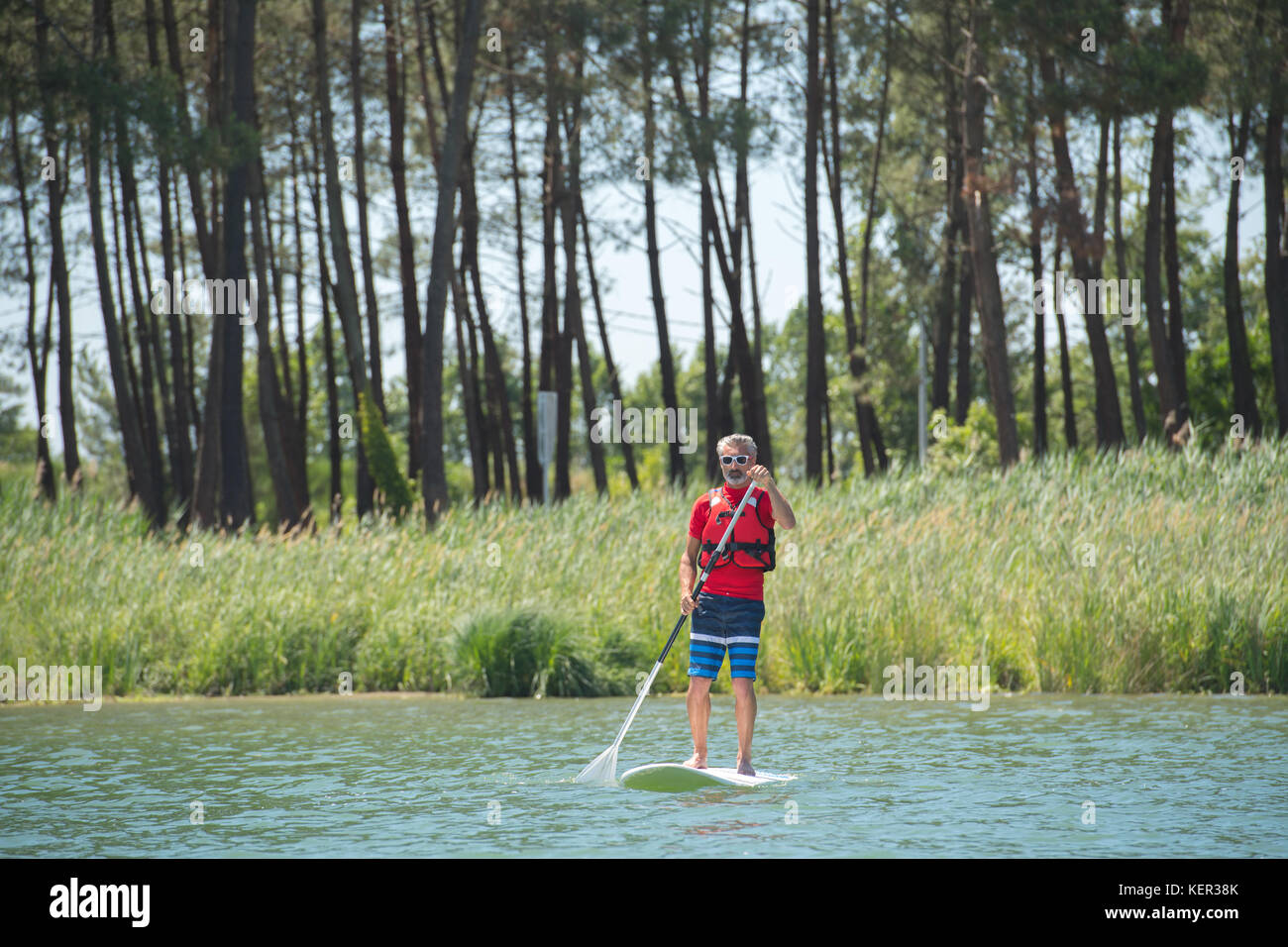 man enjoying a ride on the lake with paddleboard Stock Photo - Alamy