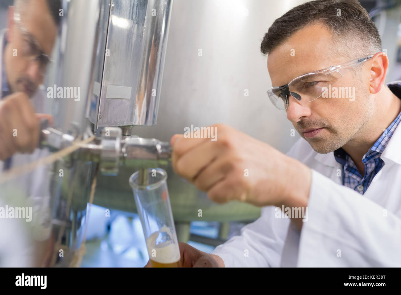 focused brewer smelling beaker with beer in the factory Stock Photo - Alamy