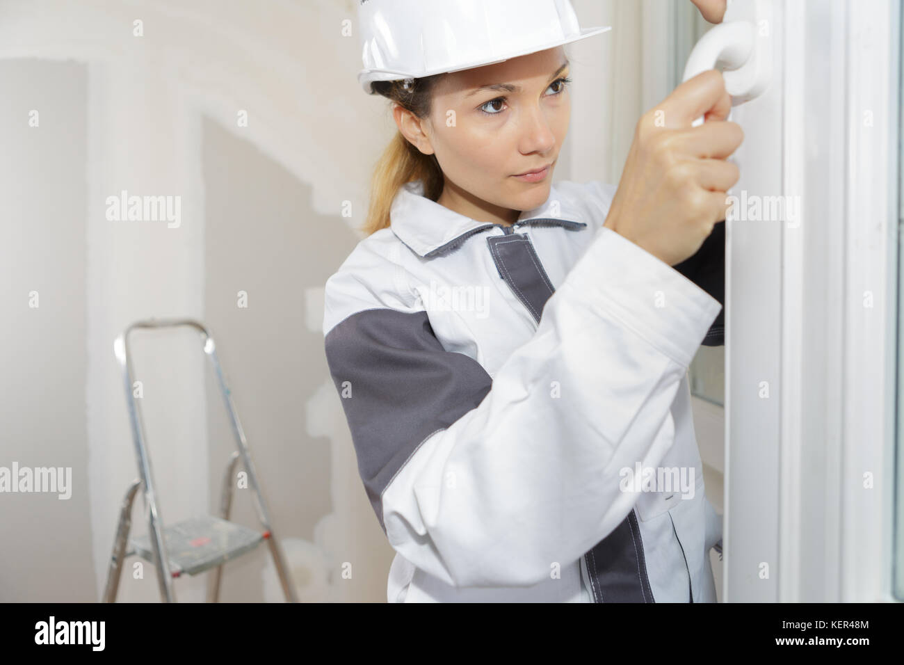 female builder installing window in a building Stock Photo - Alamy