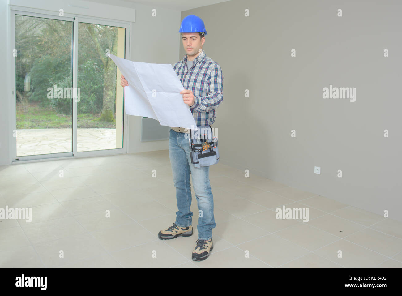builder checks plans Stock Photo - Alamy
