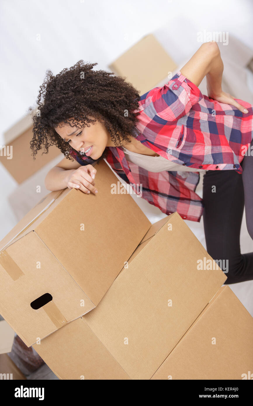 woman suffering from back pain carrying a heavy box Stock Photo - Alamy
