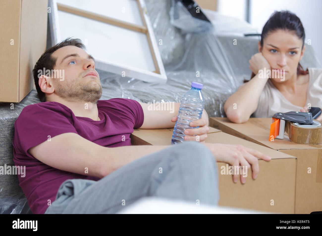 miserable couple sat amongst cardboard boxes Stock Photo - Alamy