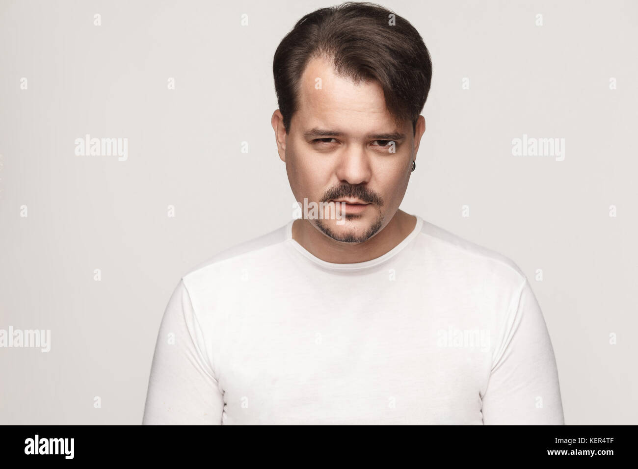 Arrogant man looking proud at camera. Studio shot, gray wall Stock ...