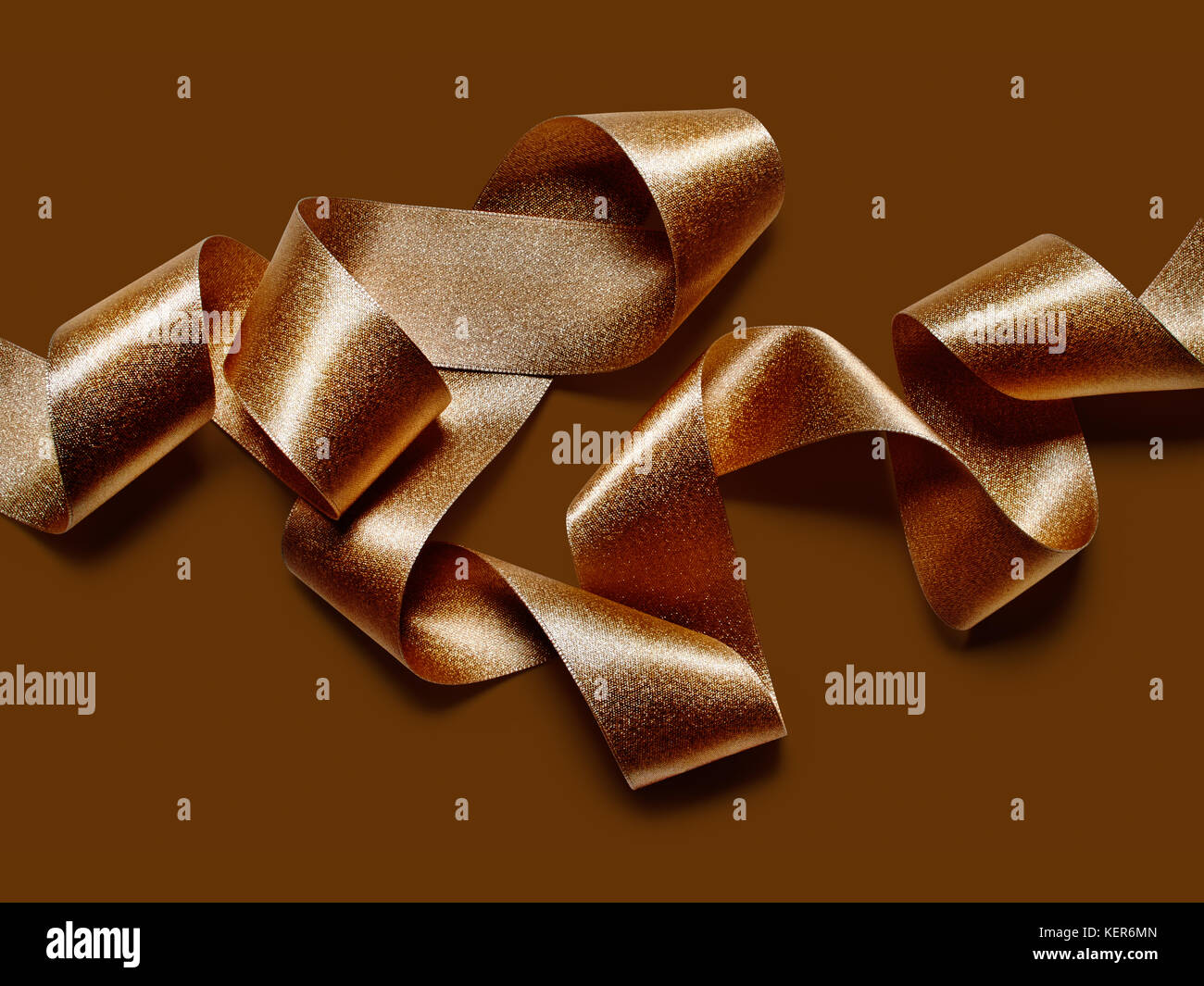 Close up of bronze metallic ribbon isolated on bronze brown background ...