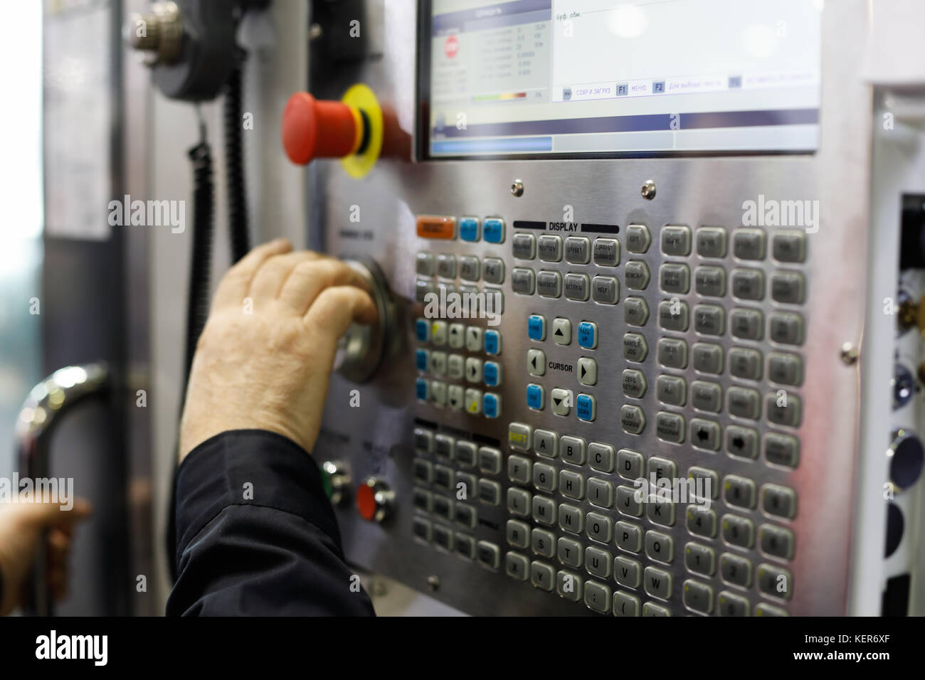 Operator working with controls of the CNC machine. Selective focus ...