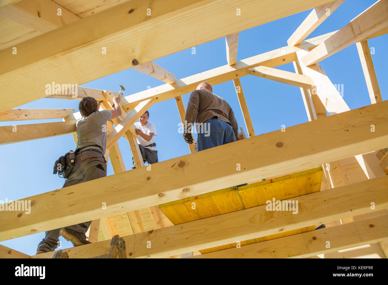 Builders at work with wooden roof construction Stock Photo - Alamy