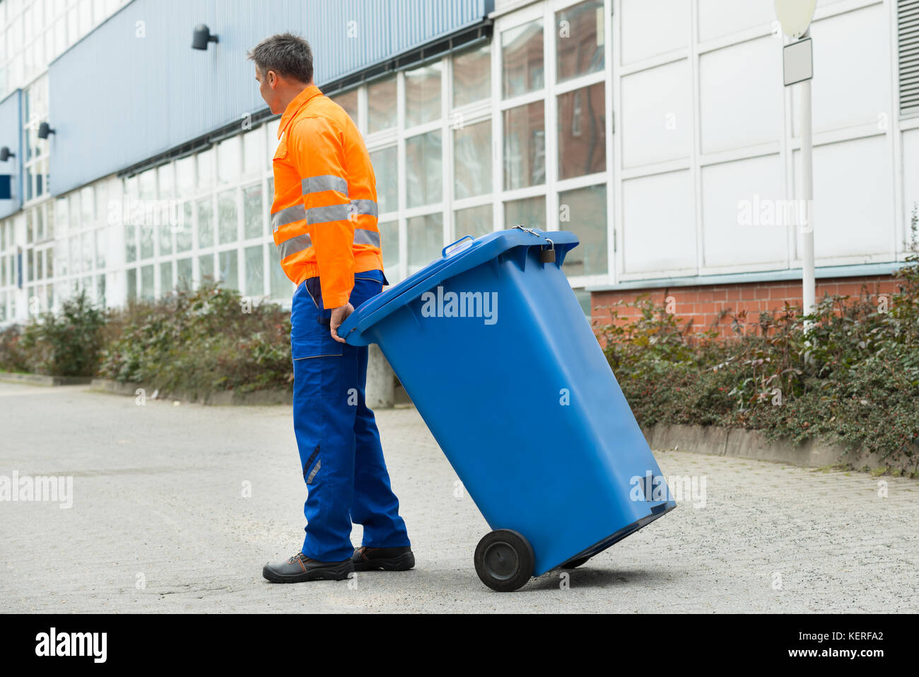 Happy Male Worker Walking With Dustbin On Street During Day Stock Photo ...