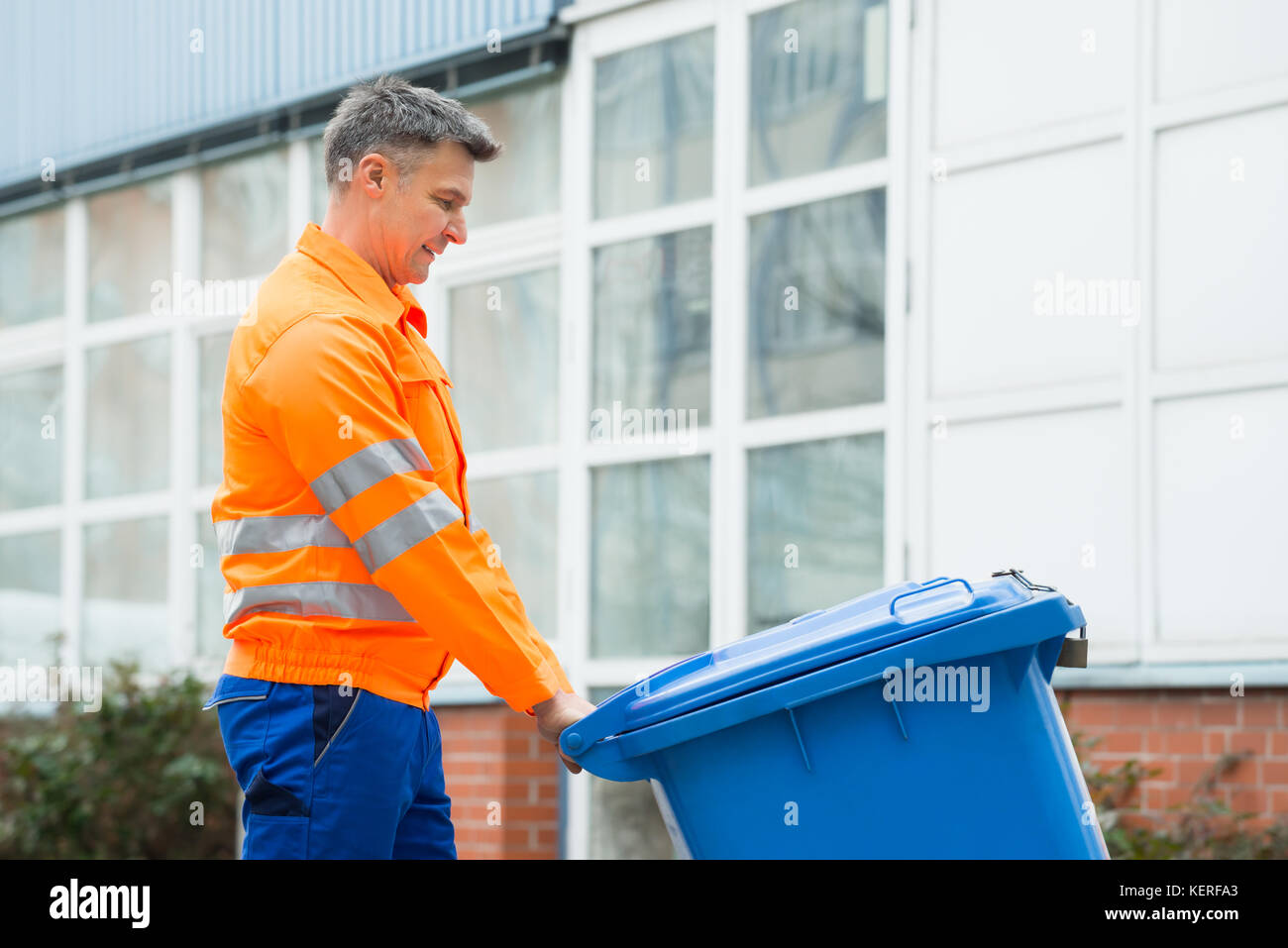 Happy Male Worker Walking With Dustbin On Street During Day Stock Photo ...