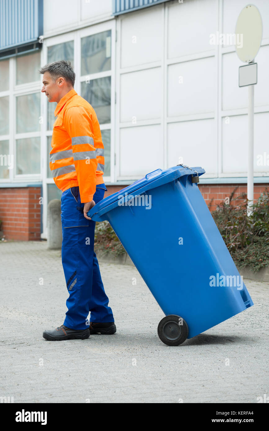Happy Male Worker Walking With Dustbin On Street During Day Stock Photo ...