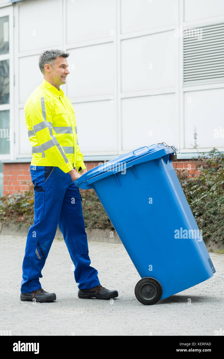 Happy Male Worker Walking With Dustbin On Street During Day Stock Photo ...