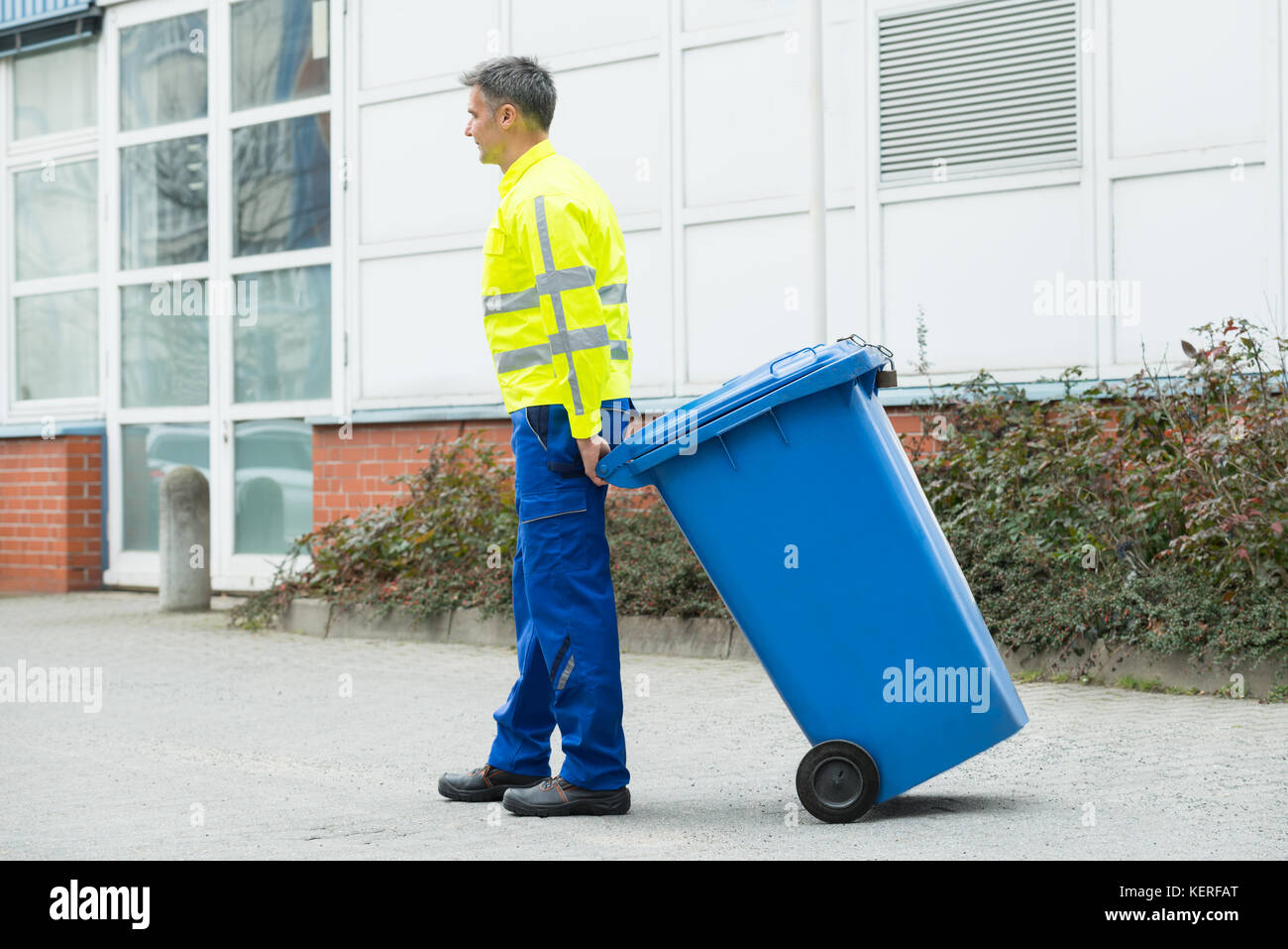 Happy Male Worker Walking With Dustbin On Street During Day Stock Photo ...