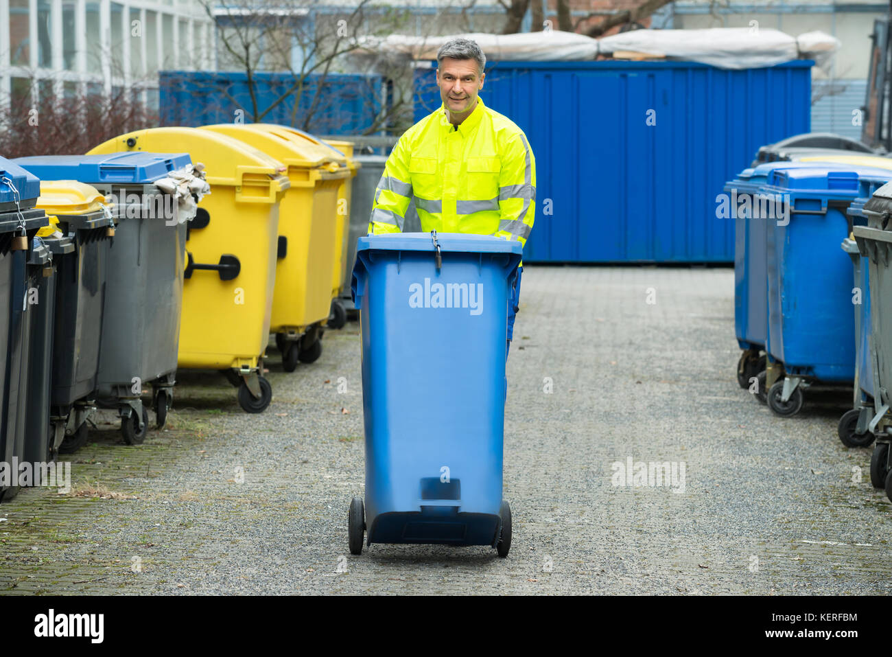 Happy Male Worker Walking With Dustbin On Street During Day Stock Photo ...