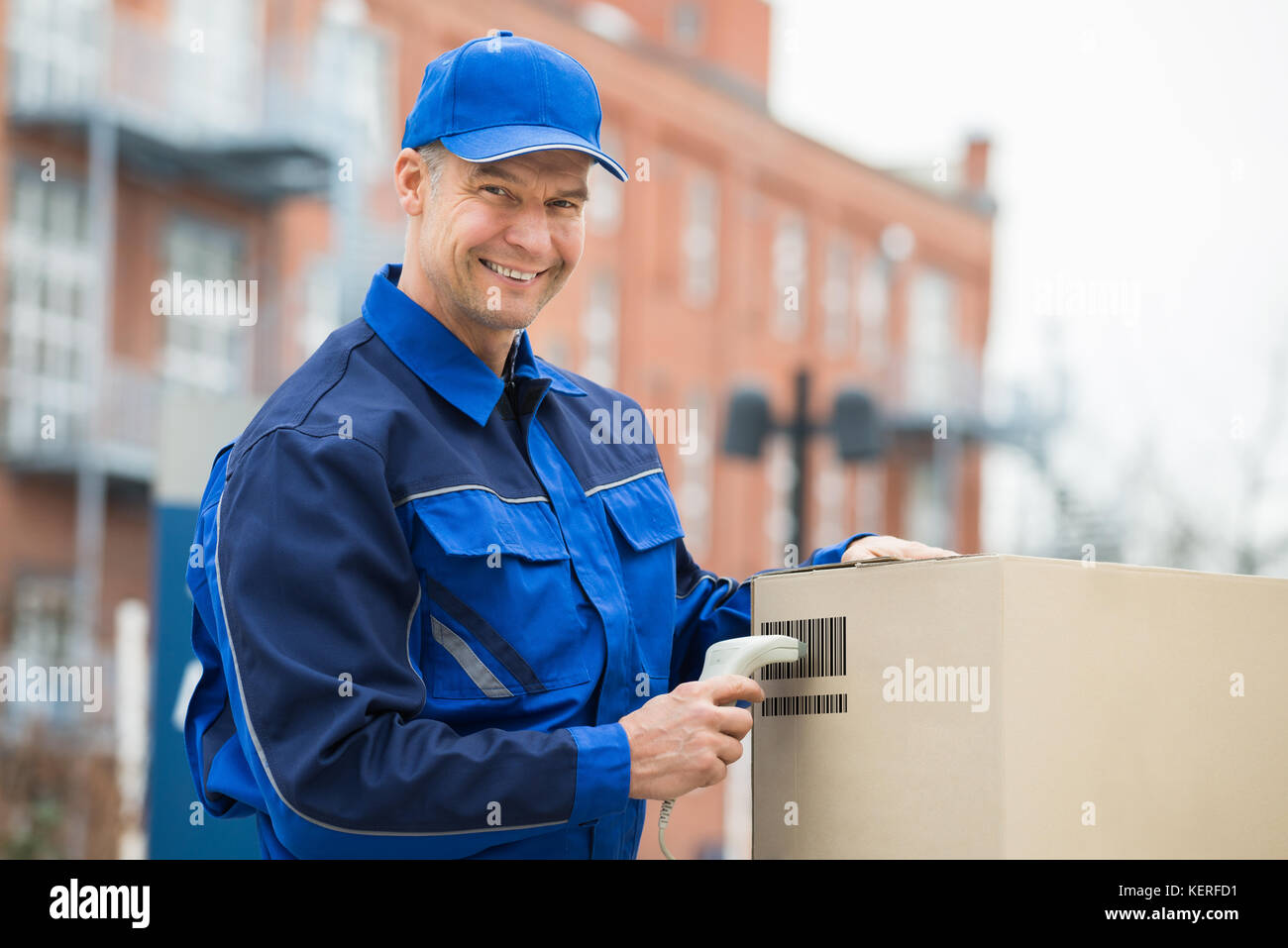 Delivery Man Standing And Scanning Cardboard Boxes With Barcode Scanner ...