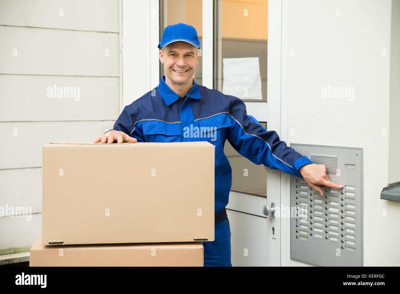 Delivery Man Using Intercom To Enter Home For Delivery Stock Photo - Alamy
