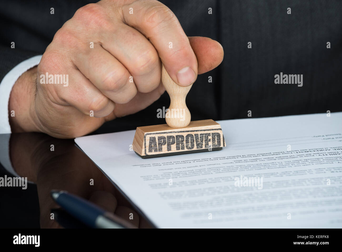 Close-up Of Businessman Hand Stamping On Approved Contract Form On Desk ...