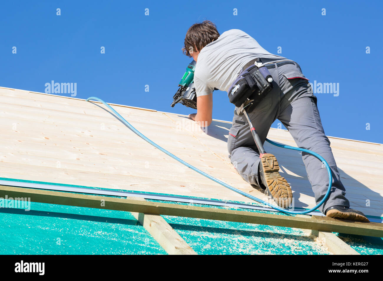 Builder at work with wooden roof construction Stock Photo - Alamy