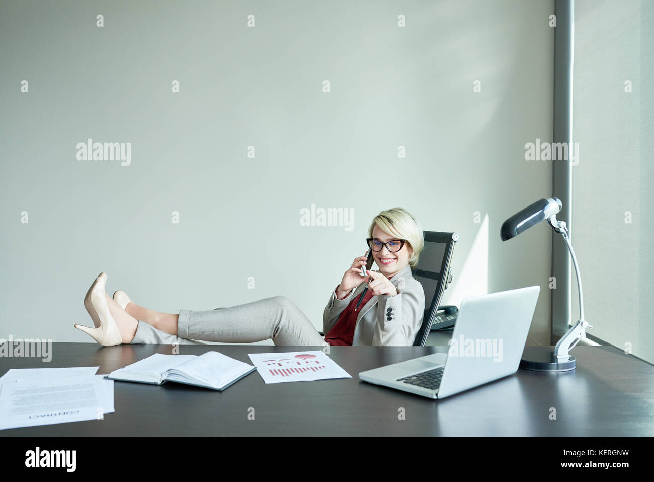 Laid-Back Businesswoman at Workplace Stock Photo - Alamy