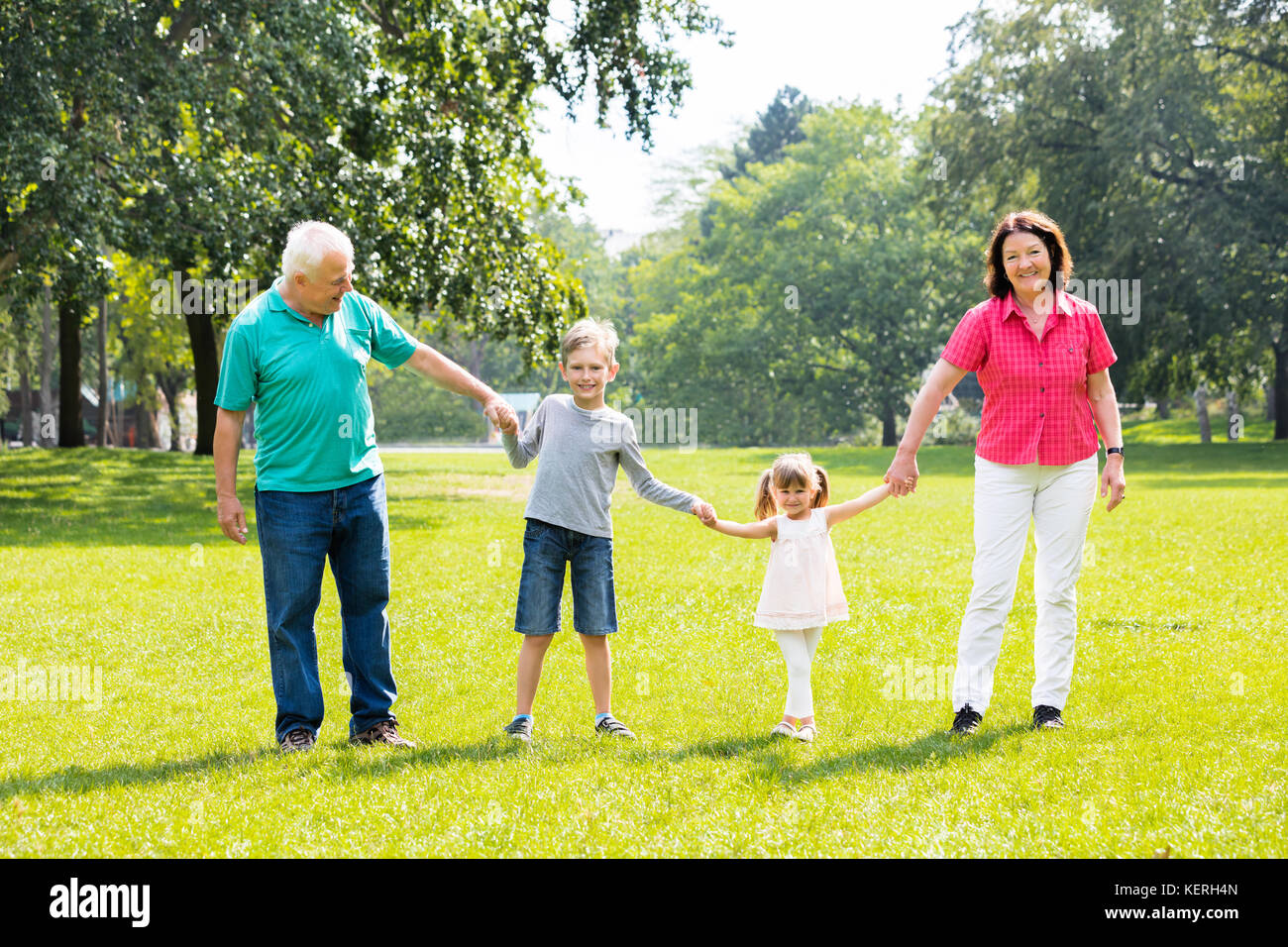 Happy Grandparents And Grandchildren Having Fun Together In Park Stock ...