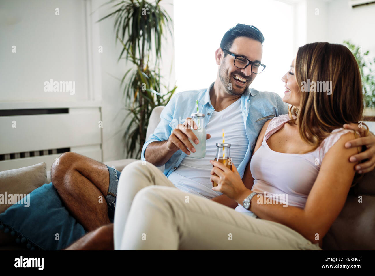 Young happy couple drinking together at home Stock Photo - Alamy