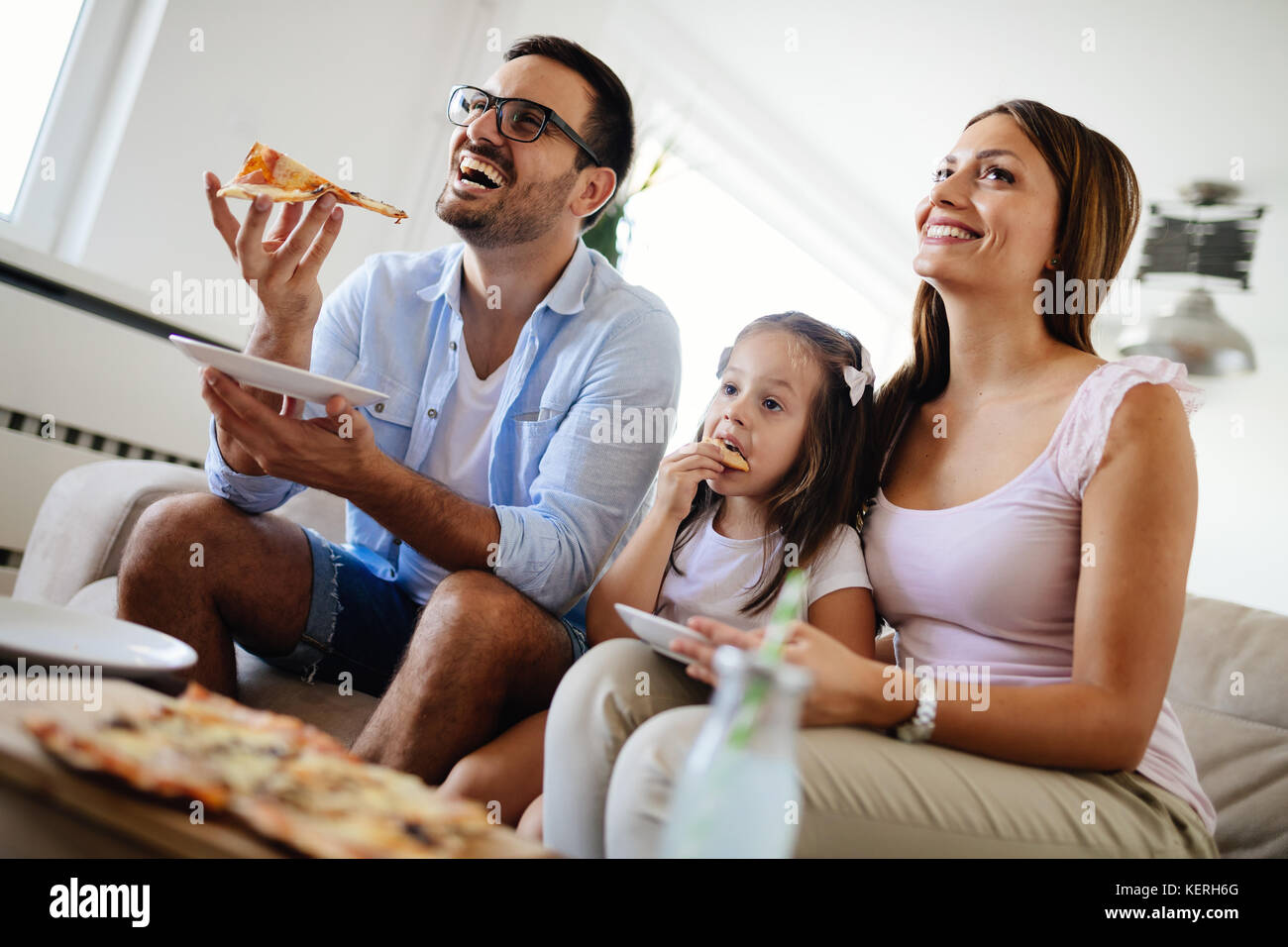 Happy family sharing pizza together at home Stock Photo - Alamy