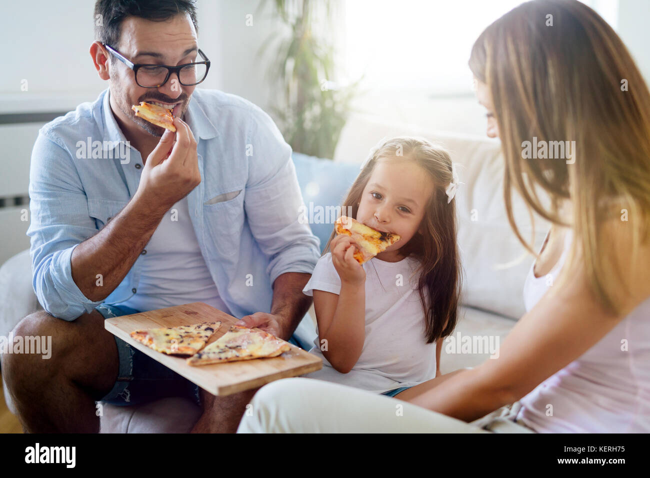 Happy family sharing pizza together at home Stock Photo - Alamy