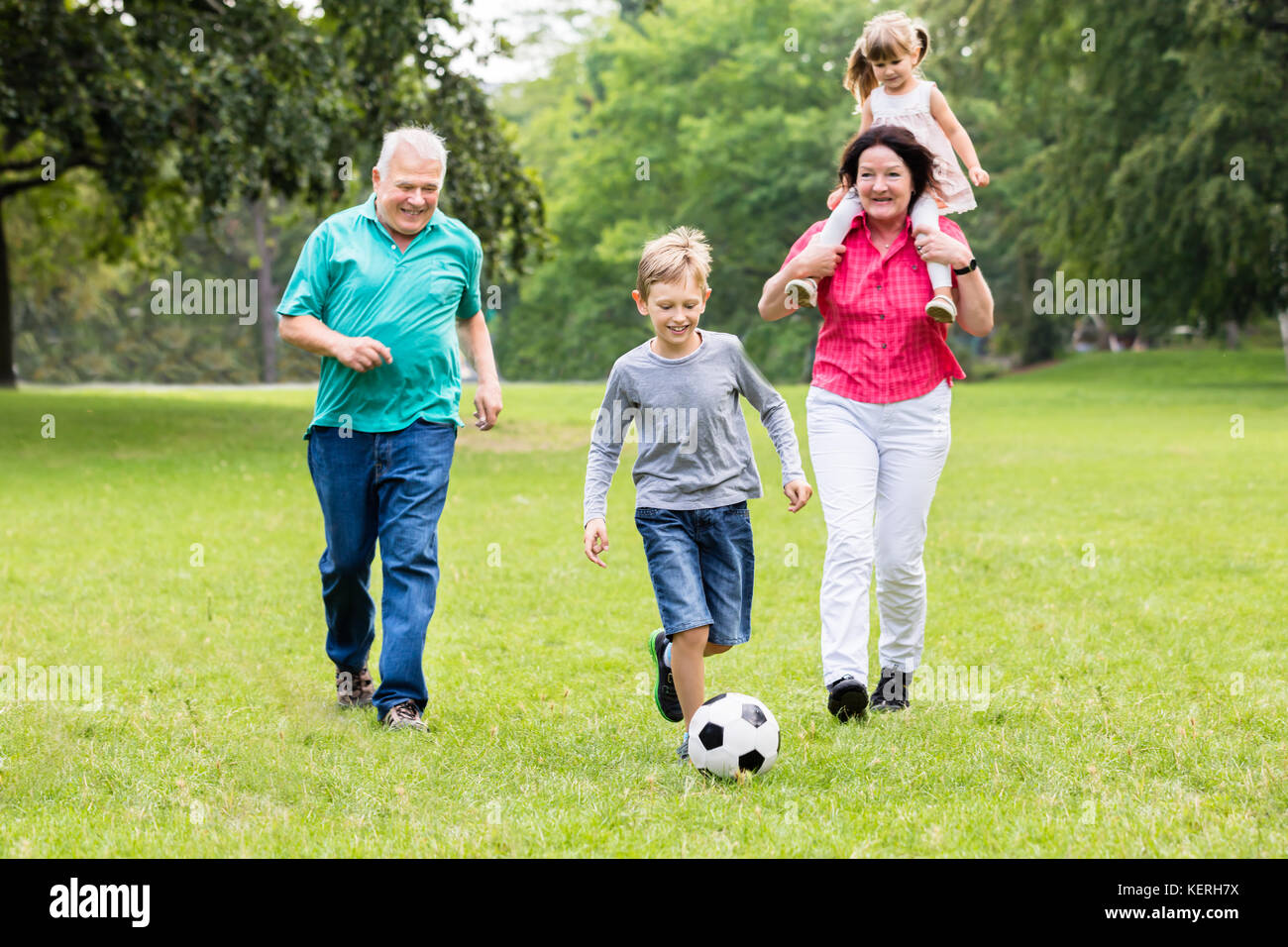 Happy Family Playing Soccer Game Together Running For Ball Stock Photo ...