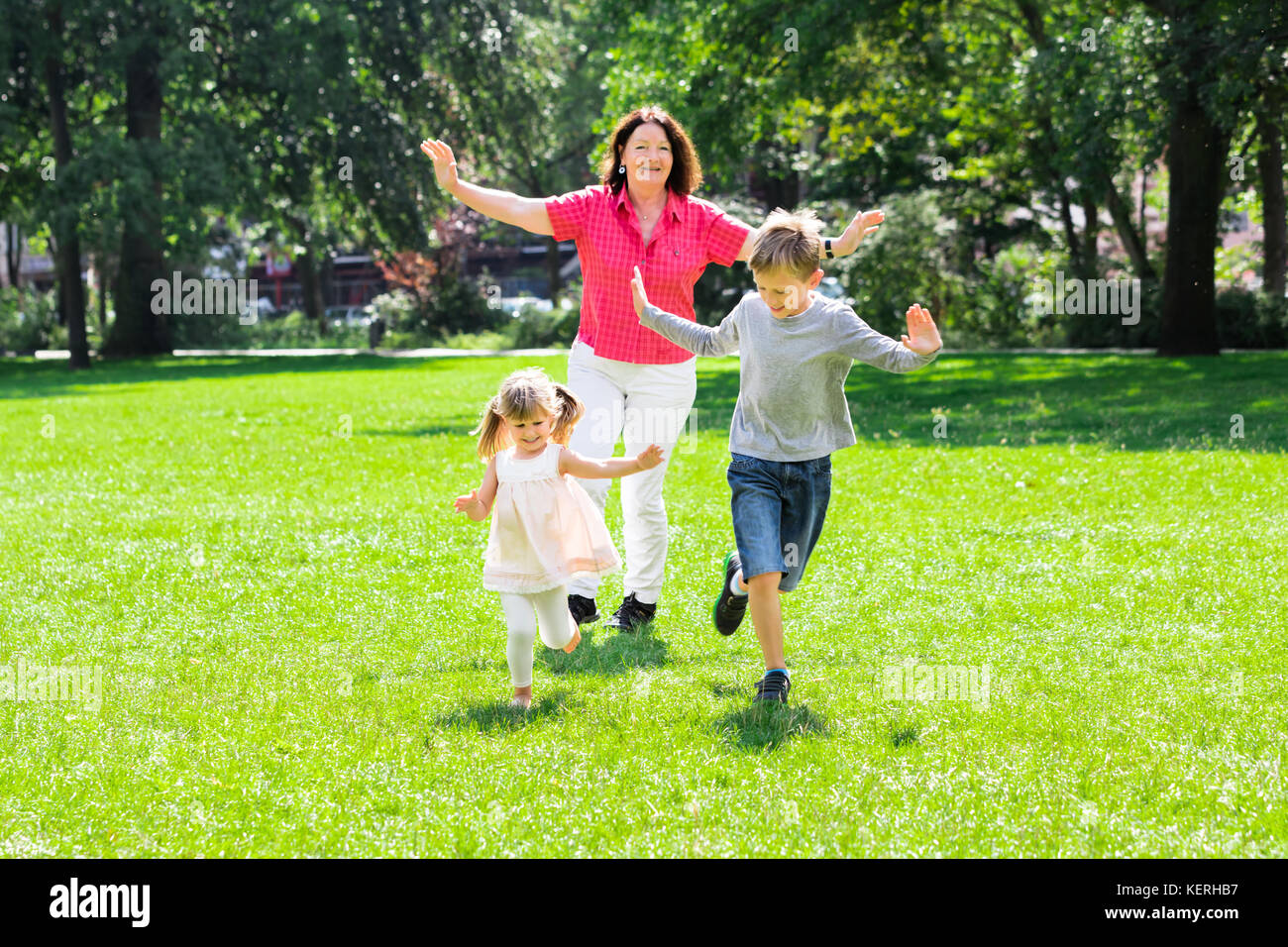 Happy Elderly Grandmother Having Fun While Running With Kids In Park ...