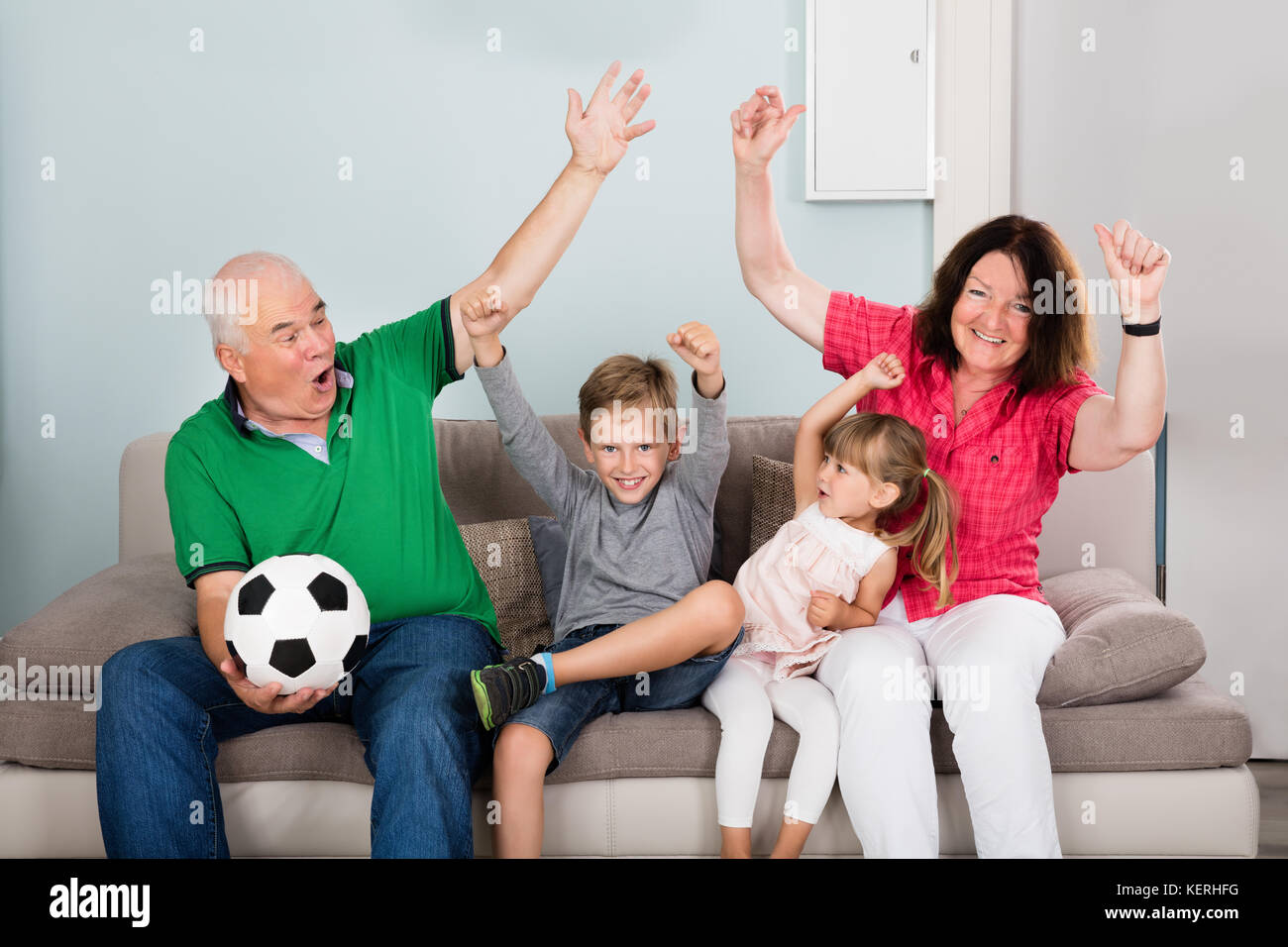Family Of Soccer Fans Watching Football Match On Television With ...