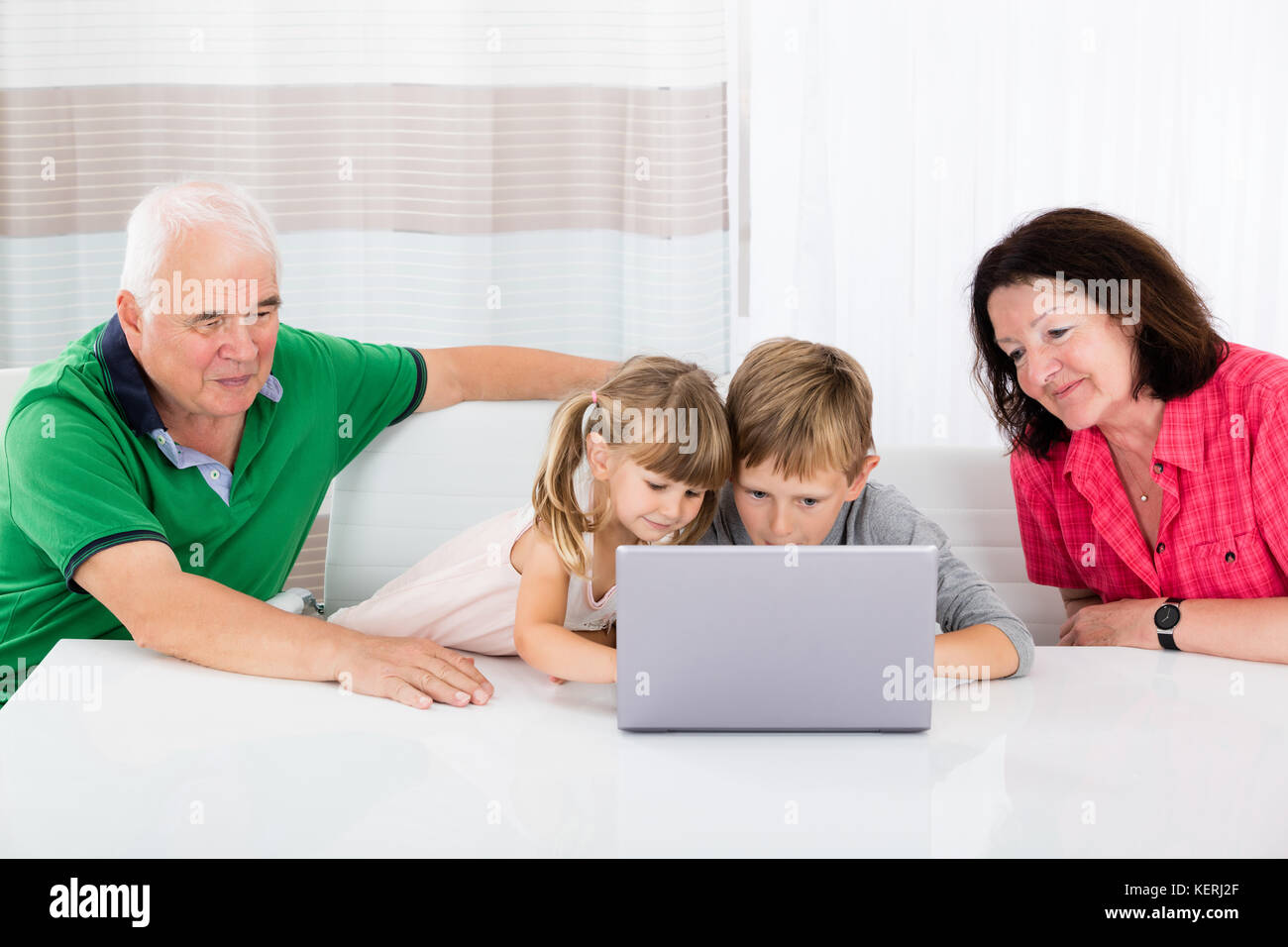 Smiling Kids Using Laptop Computer With Happy Family At Home Stock ...