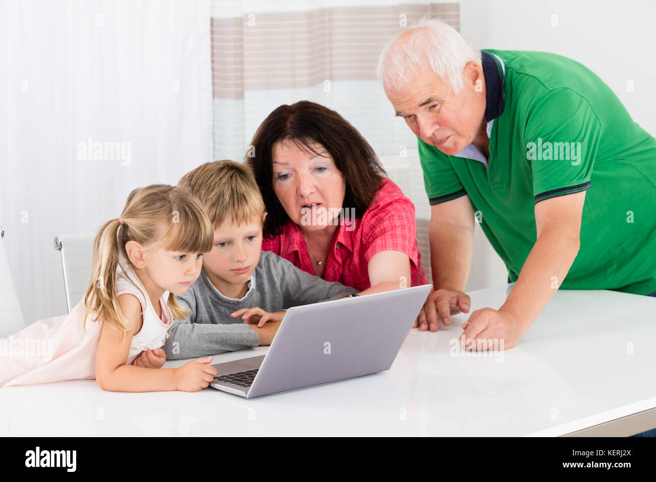 Happy Family Using Laptop Computer With Kids To Browse Internet Stock ...