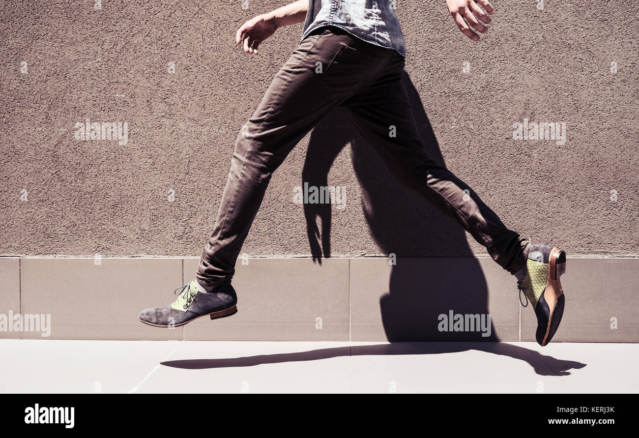 Young man walk and jump. There are shadows Stock Photo - Alamy