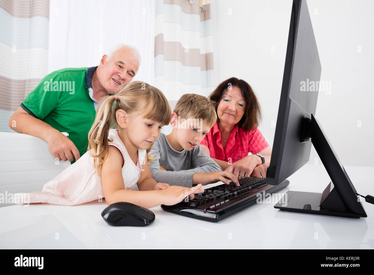 Happy Grandparents Playing With Kids At Laptop Computer Stock Photo - Alamy