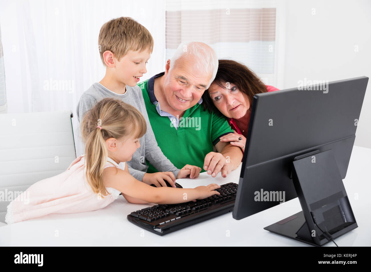 Happy Grandparents Learning To Use Desktop Computer From Their ...