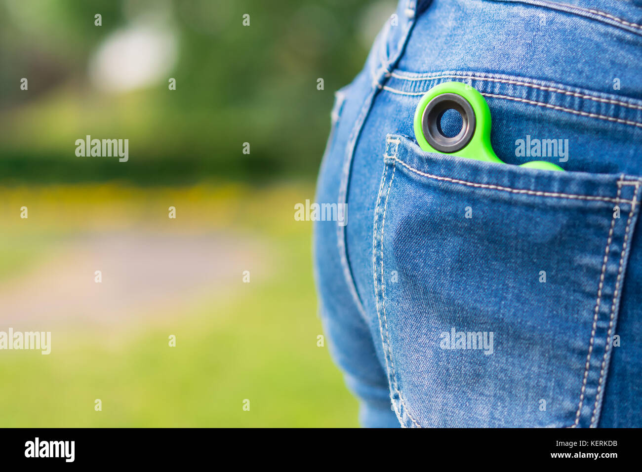 Green spinner toy for nerve lies in a pocket on a background of green ...