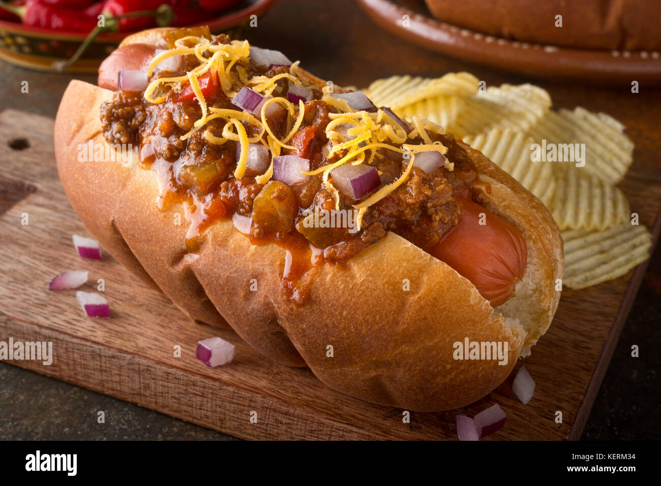 A delicious home made chili hot dog with red onion and cheddar cheese ...