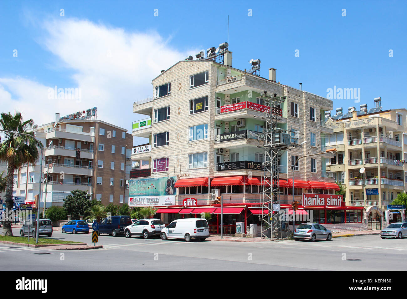 A broad avenue with palm trees at the edge of the road, simple concrete ...