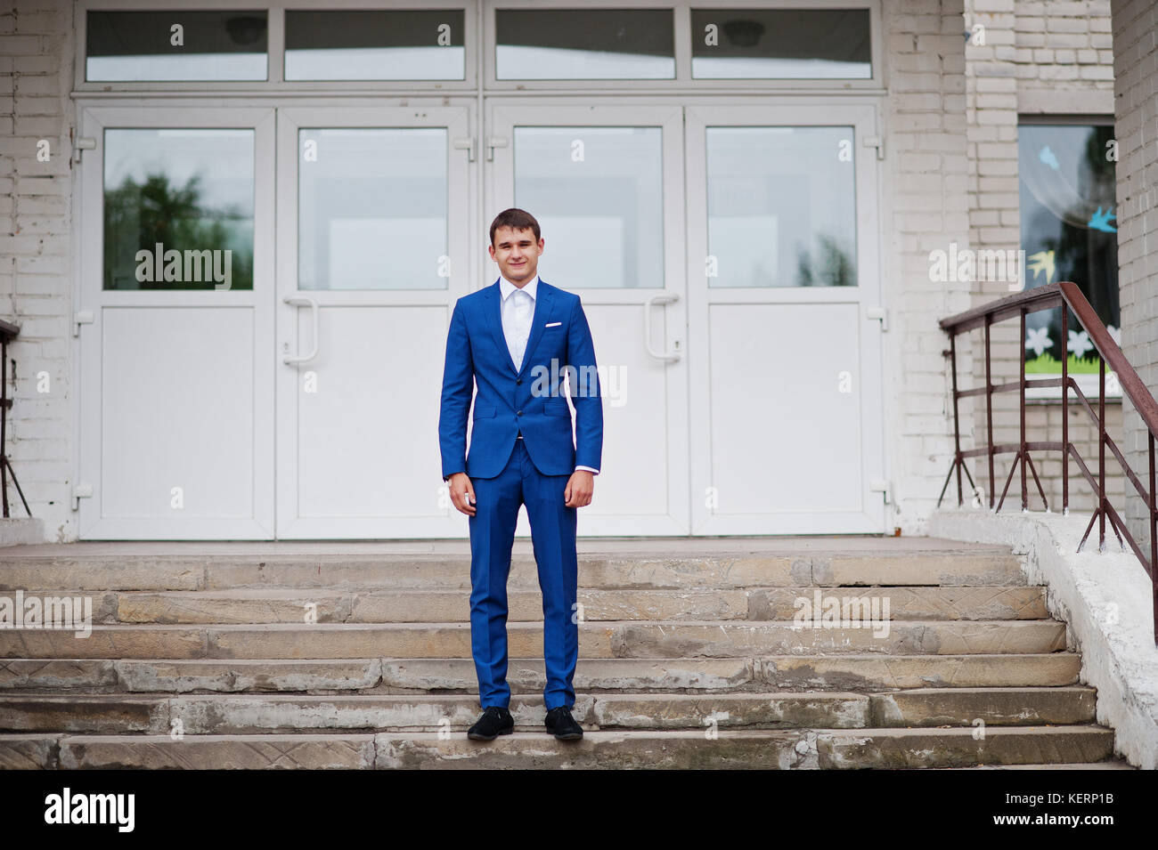 Portrait of a handsome high school graduate in stylish tuxedo posing on ...